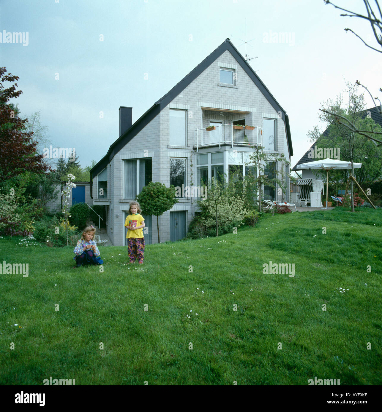 Children playing on lawn in front of German country house Stock Photo ...