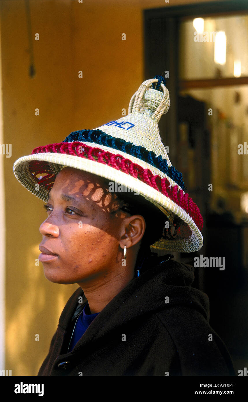 Native lady in traditional hat with red and blue trim in the Lesotho ...