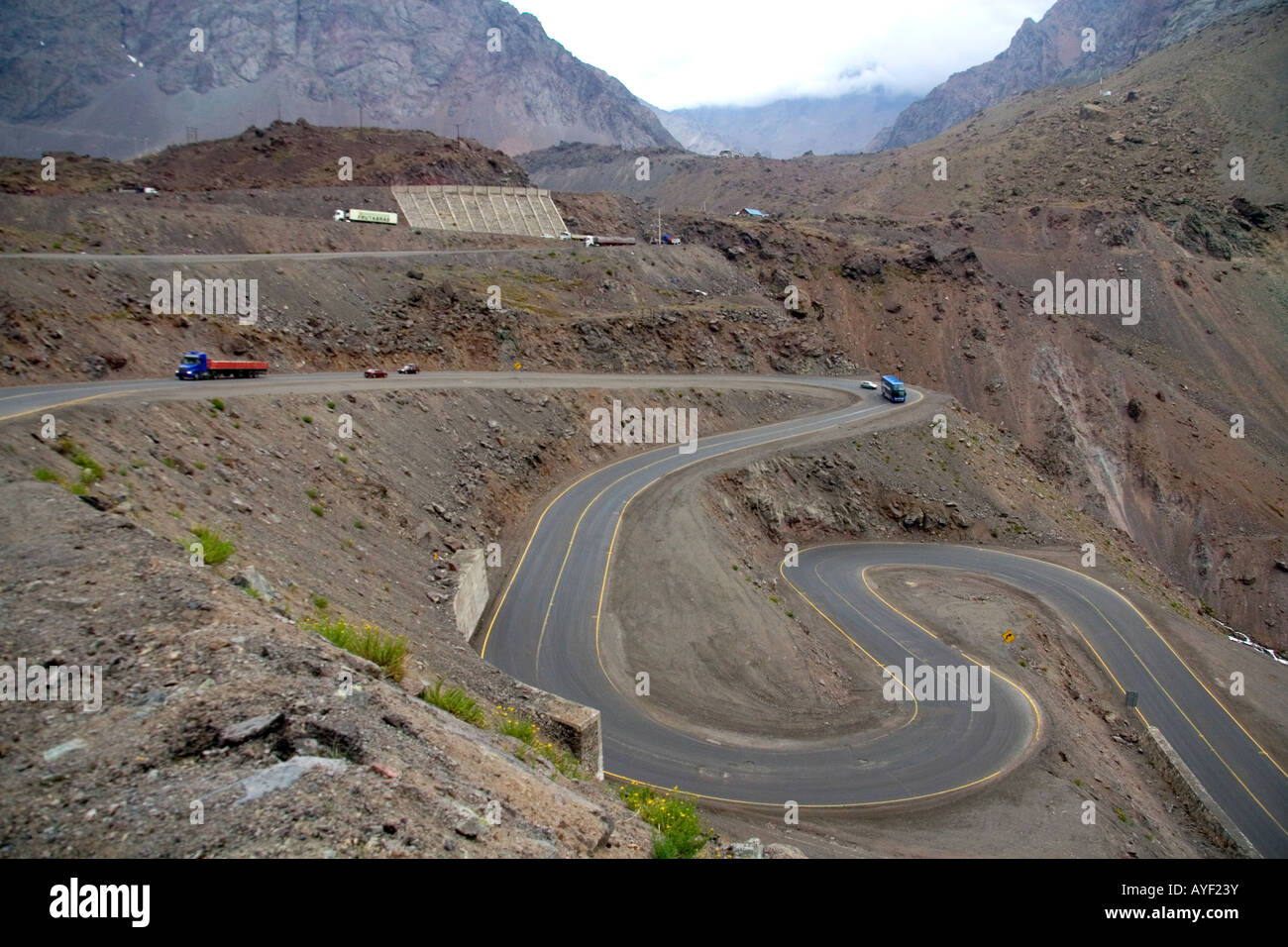 Vehicles drive on switchback roads in the Andes Mountain Range Chile ...