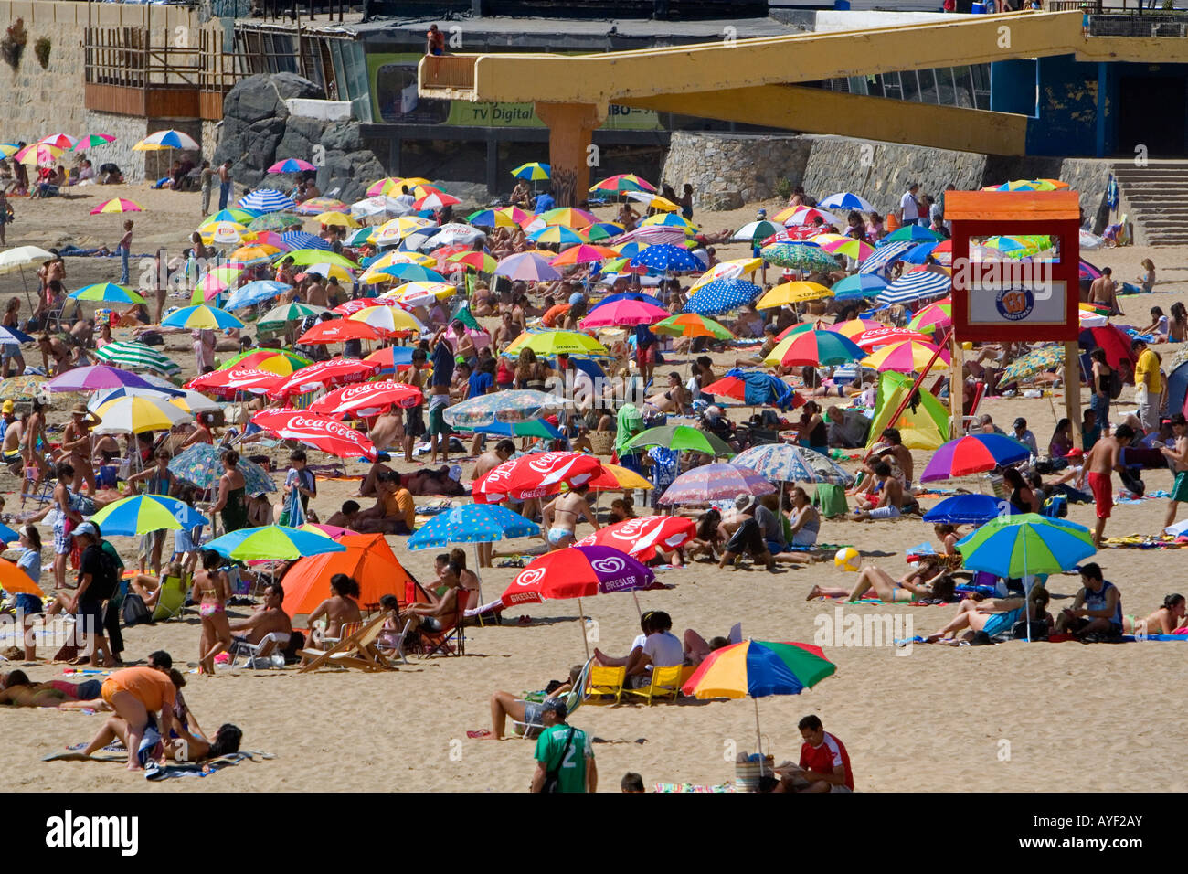 People sit under umbrellas for shade on the beach at Concon Chile Stock ...