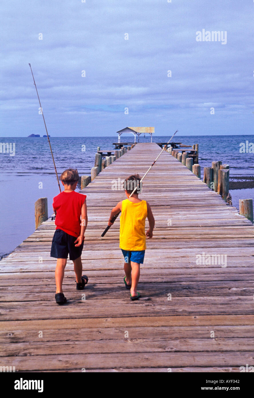 two boys going fishing on a pier Stock Photo - Alamy