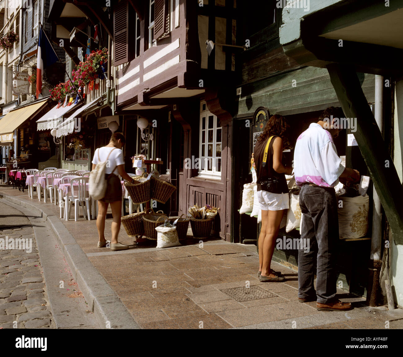 Passers by browsing in the old shops of the Quai Ste Catherine Honfleur ...