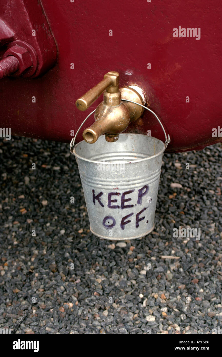 Miniature bucket under drain tap on traction engine Stock Photo - Alamy