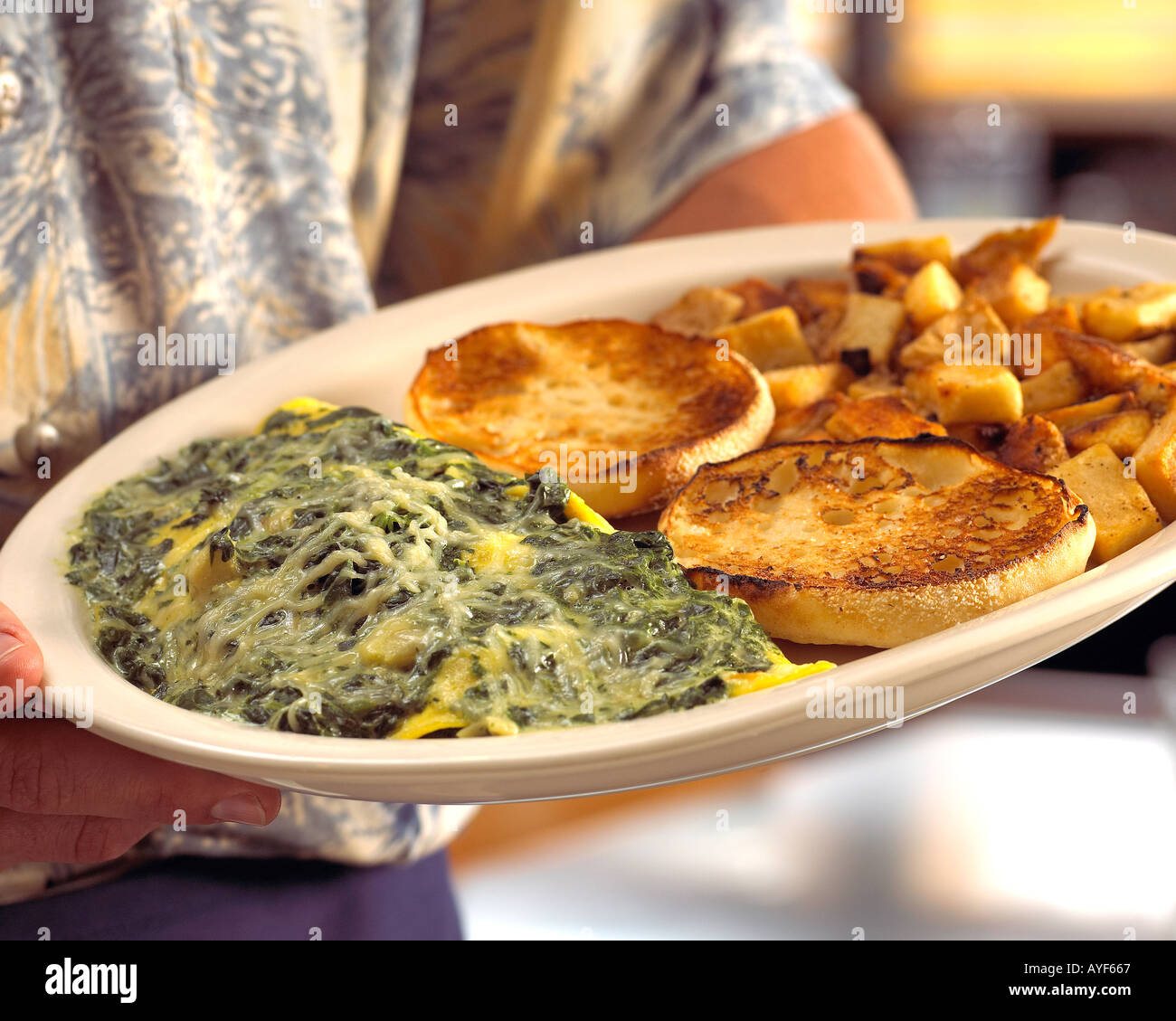 Restaurant server holding spinach and cheese omlette with english ...
