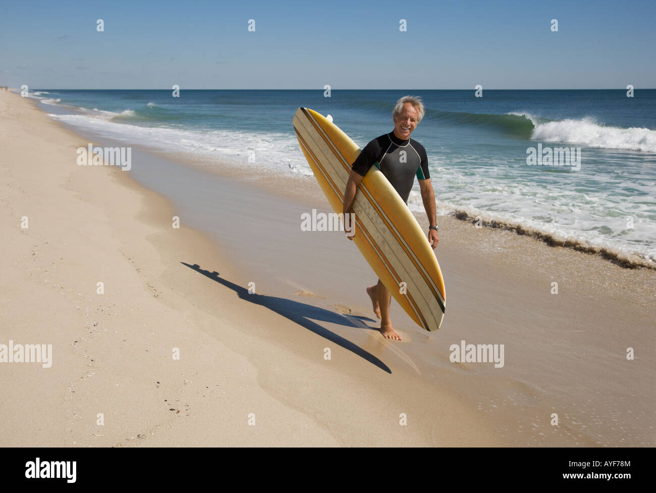 Man carrying surfboard at beach Stock Photo - Alamy