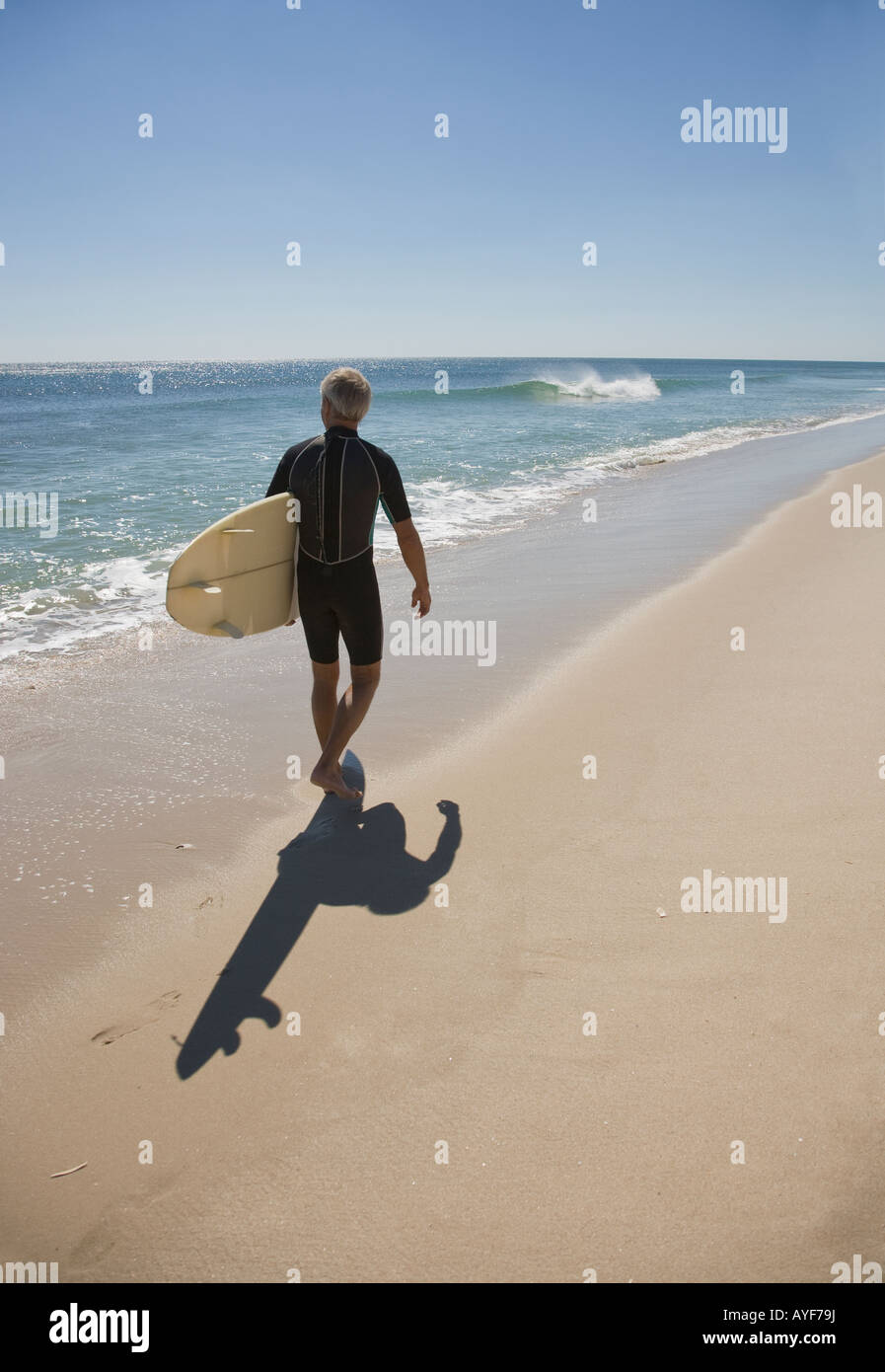 Man carrying surfboard at beach Stock Photo - Alamy