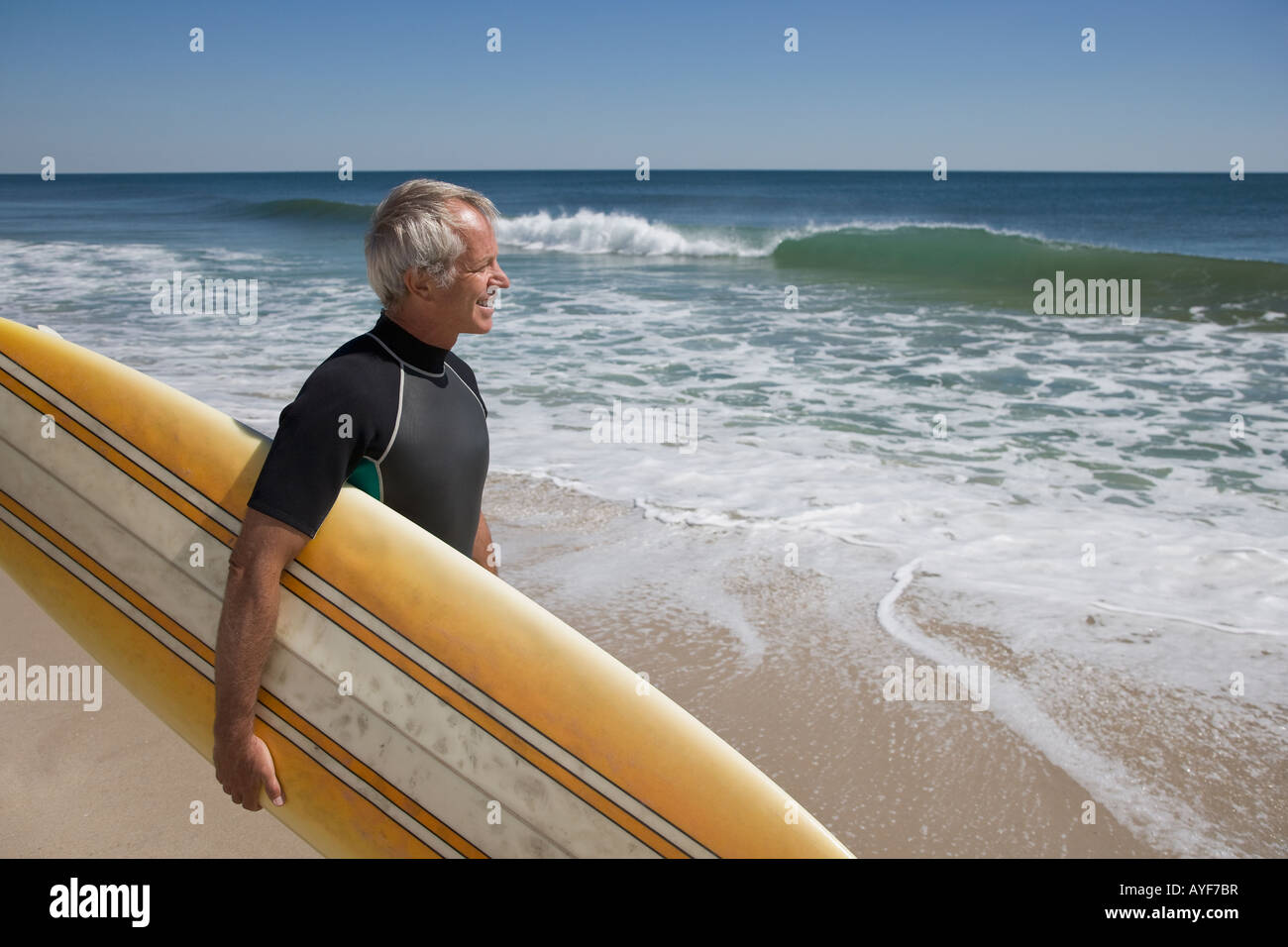 Man holding surfboard at beach Stock Photo - Alamy