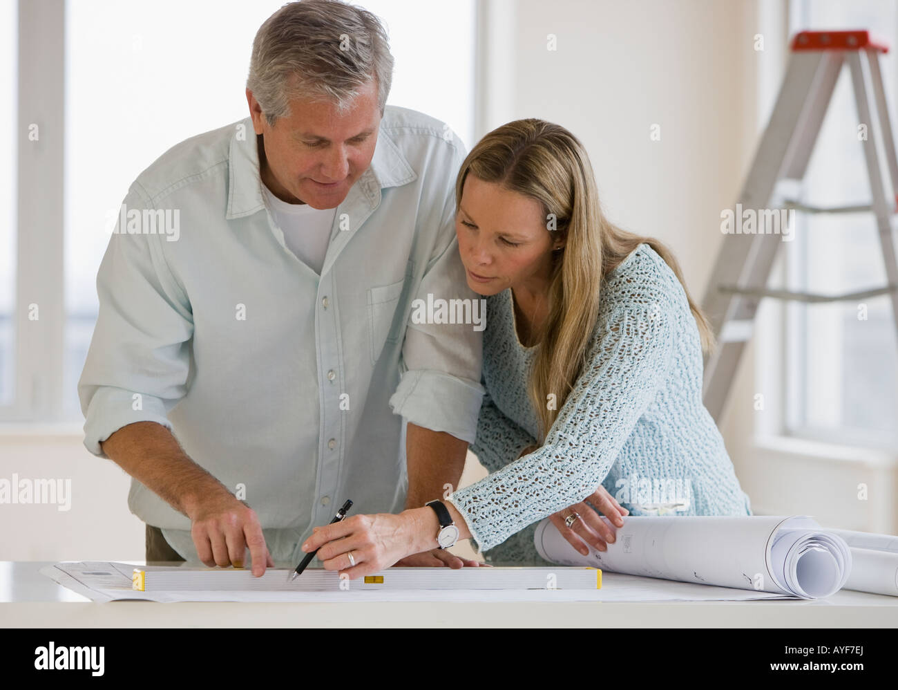 Couple looking at blueprints Stock Photo - Alamy