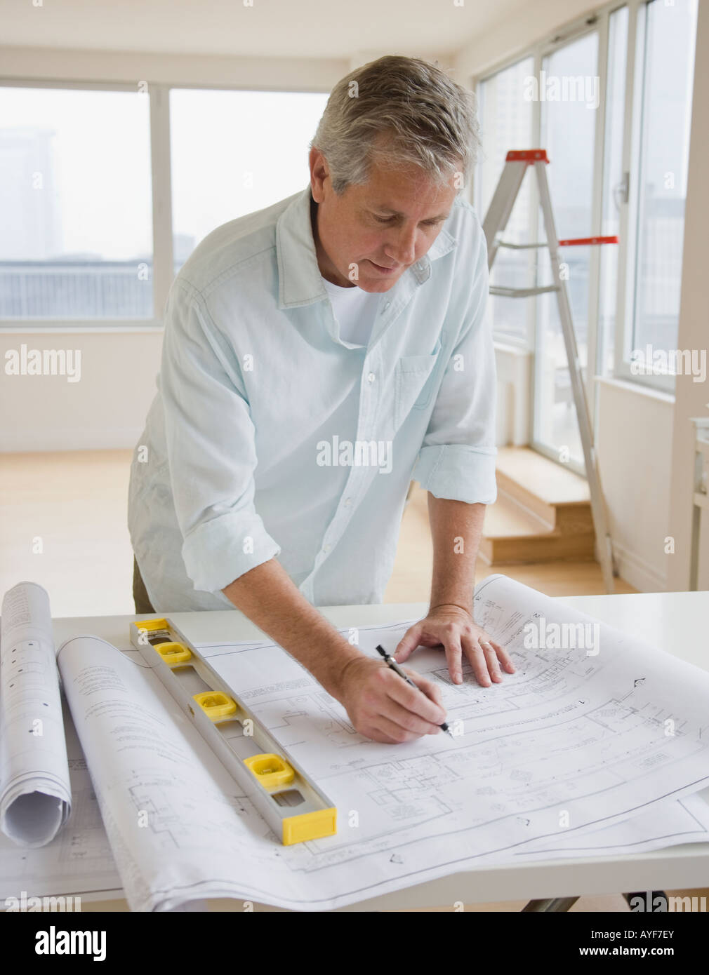 Man writing on blueprints Stock Photo - Alamy