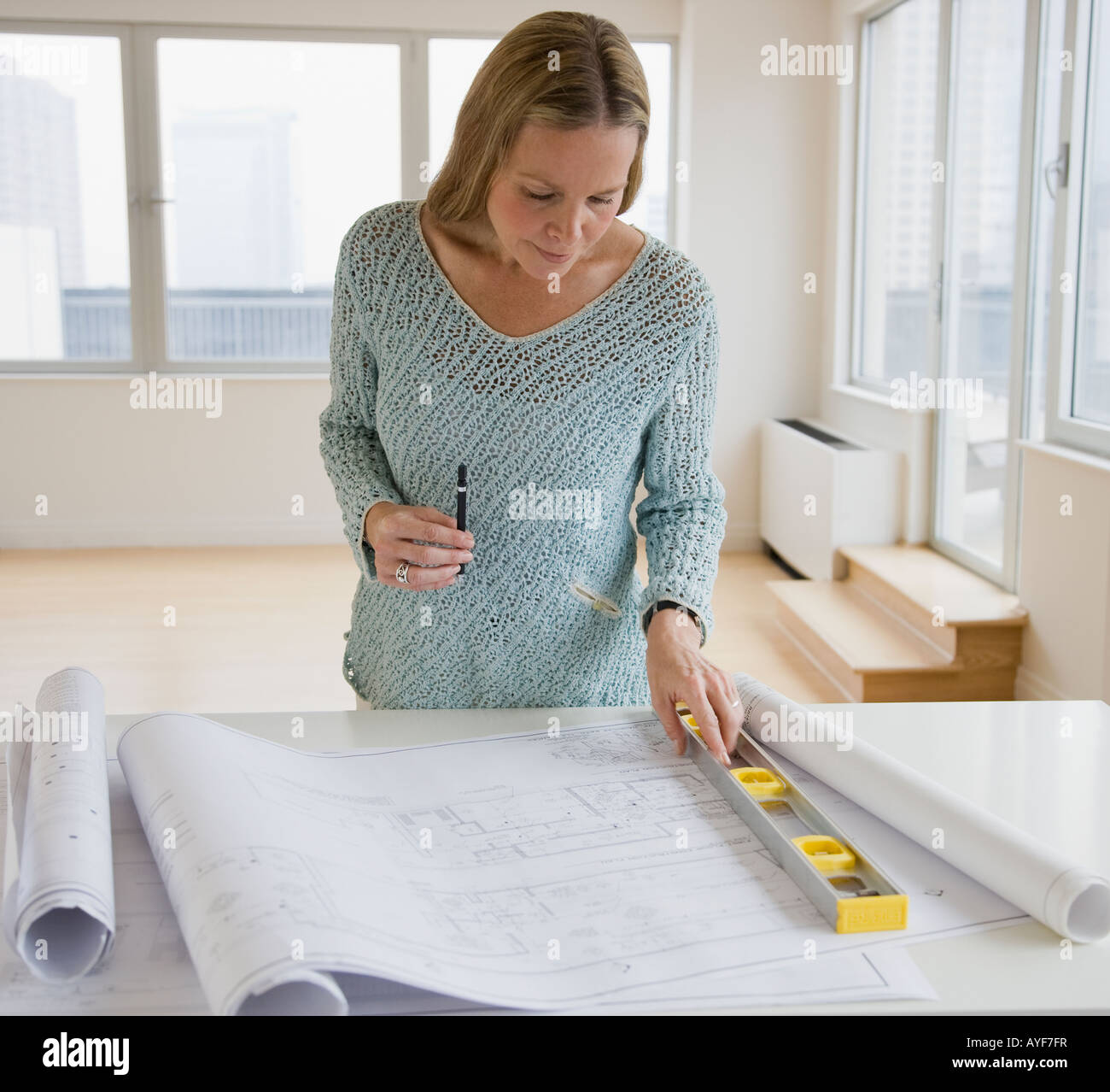 Woman looking at blueprints Stock Photo - Alamy