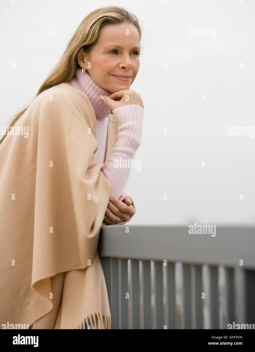 Woman leaning on railing Stock Photo - Alamy