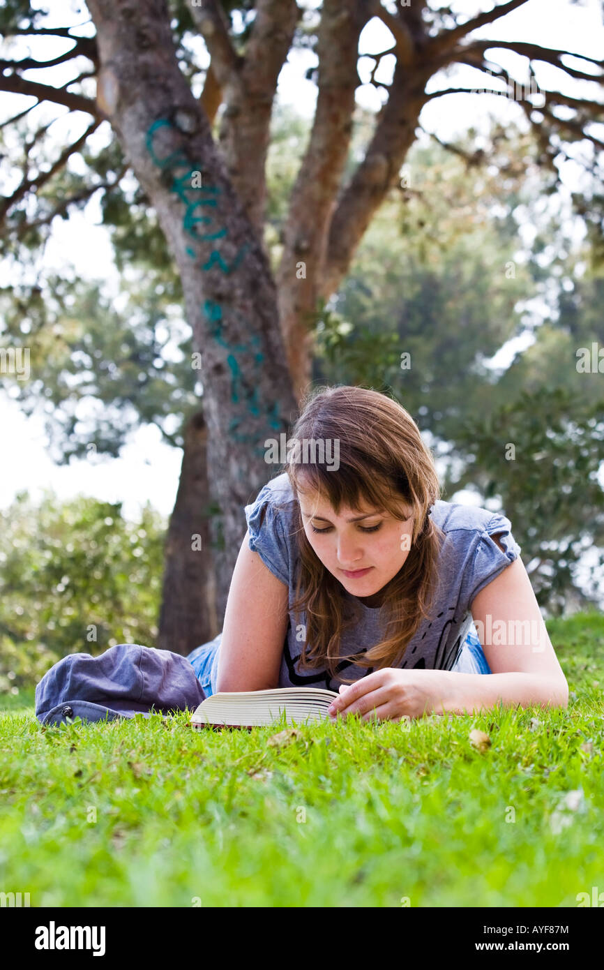 Young woman reading over the grass Stock Photo - Alamy