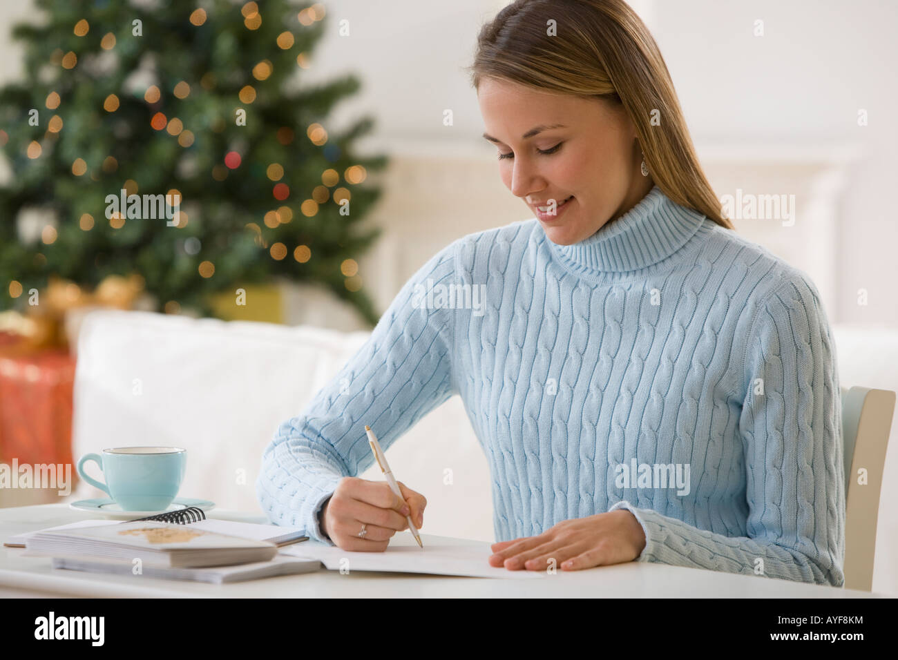 Woman writing at desk Stock Photo - Alamy