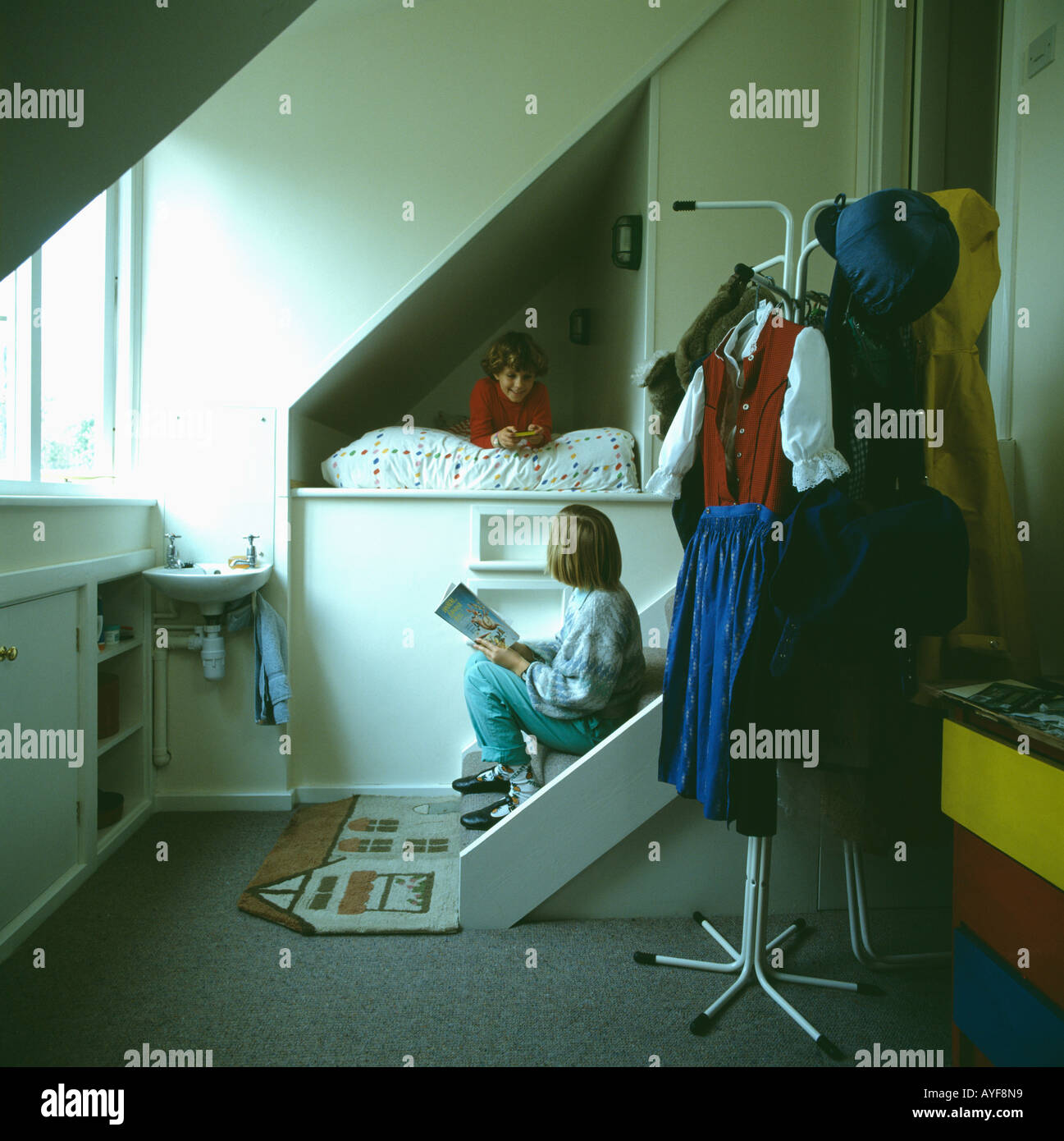 Children in bedroom reading and playing Stock Photo - Alamy