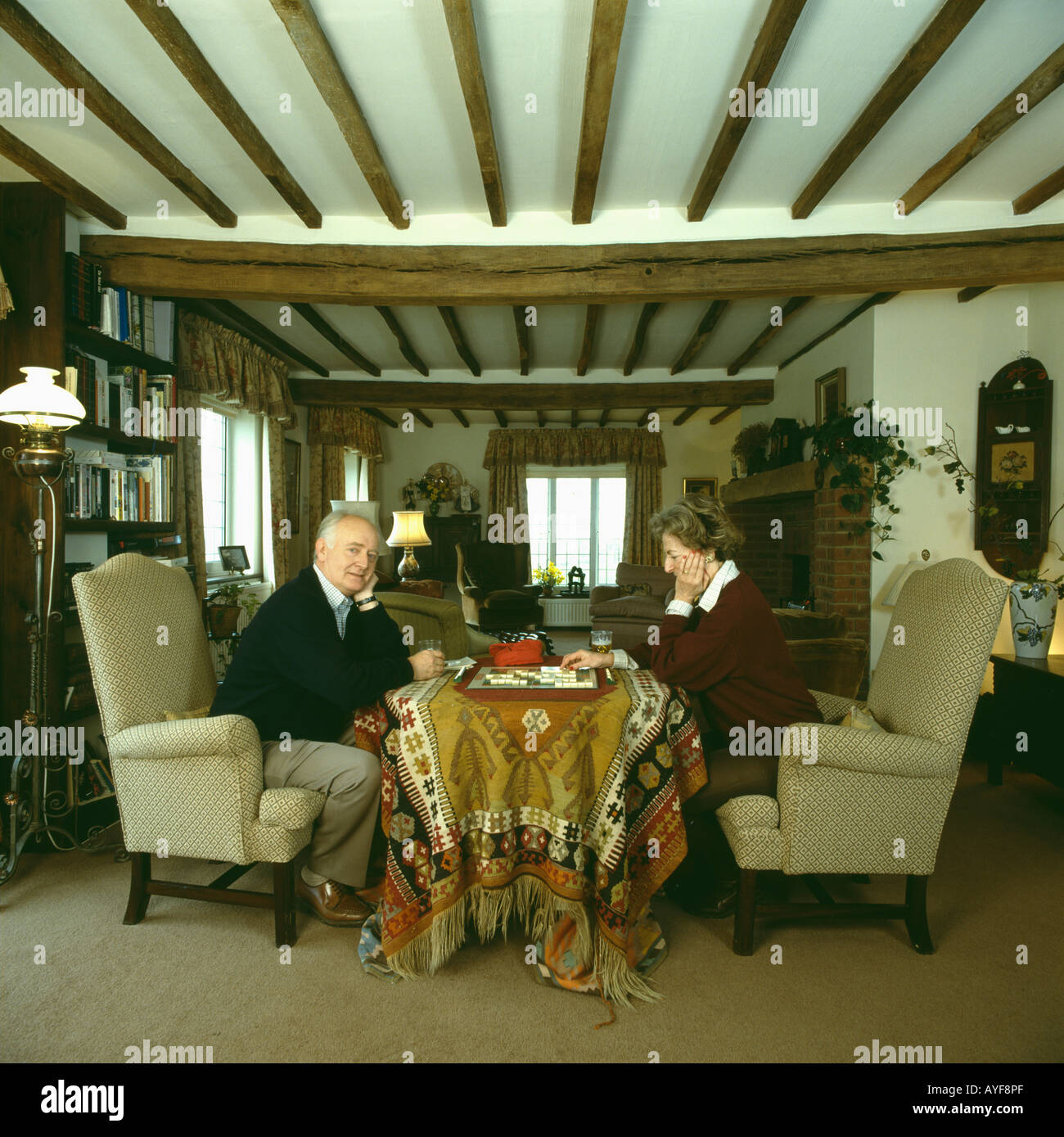 Couple playing backgammon in traditional country living-room FOR ...