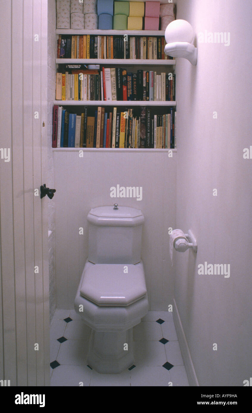 Books on shelves above white toilet in bathroom Stock Photo - Alamy