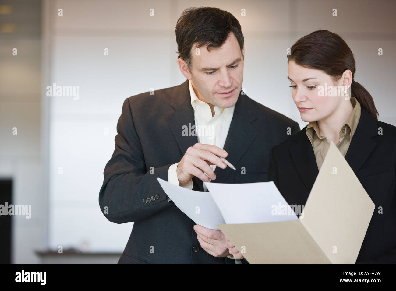 Businesspeople reading looking at paperwork Stock Photo - Alamy