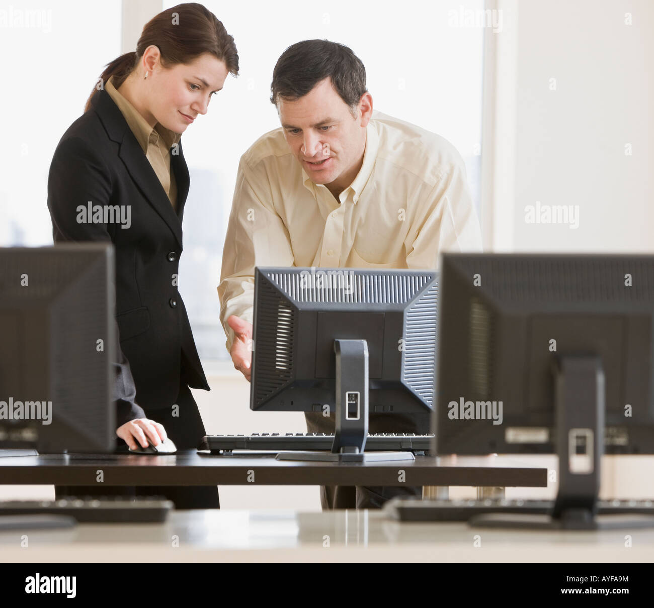 Businesspeople looking at computer Stock Photo - Alamy