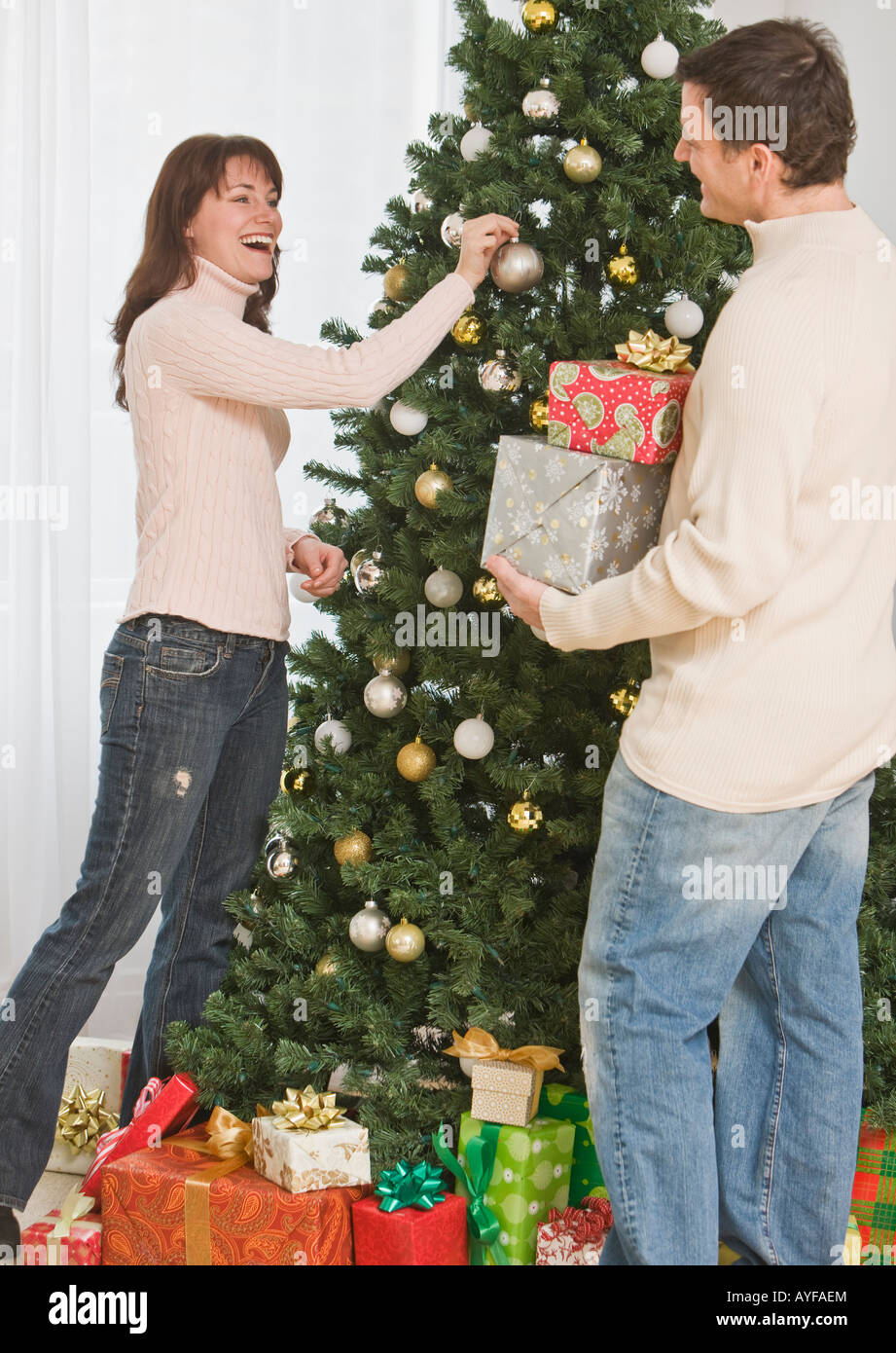 Couple decorating Christmas tree Stock Photo - Alamy