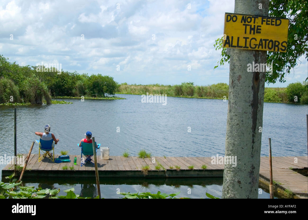 Two Caucasian men fishing together along the waterfront in Miami ...