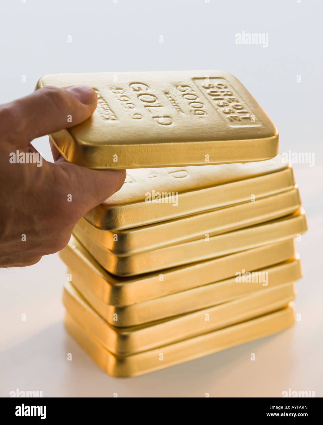 Man picking up gold bar Stock Photo - Alamy