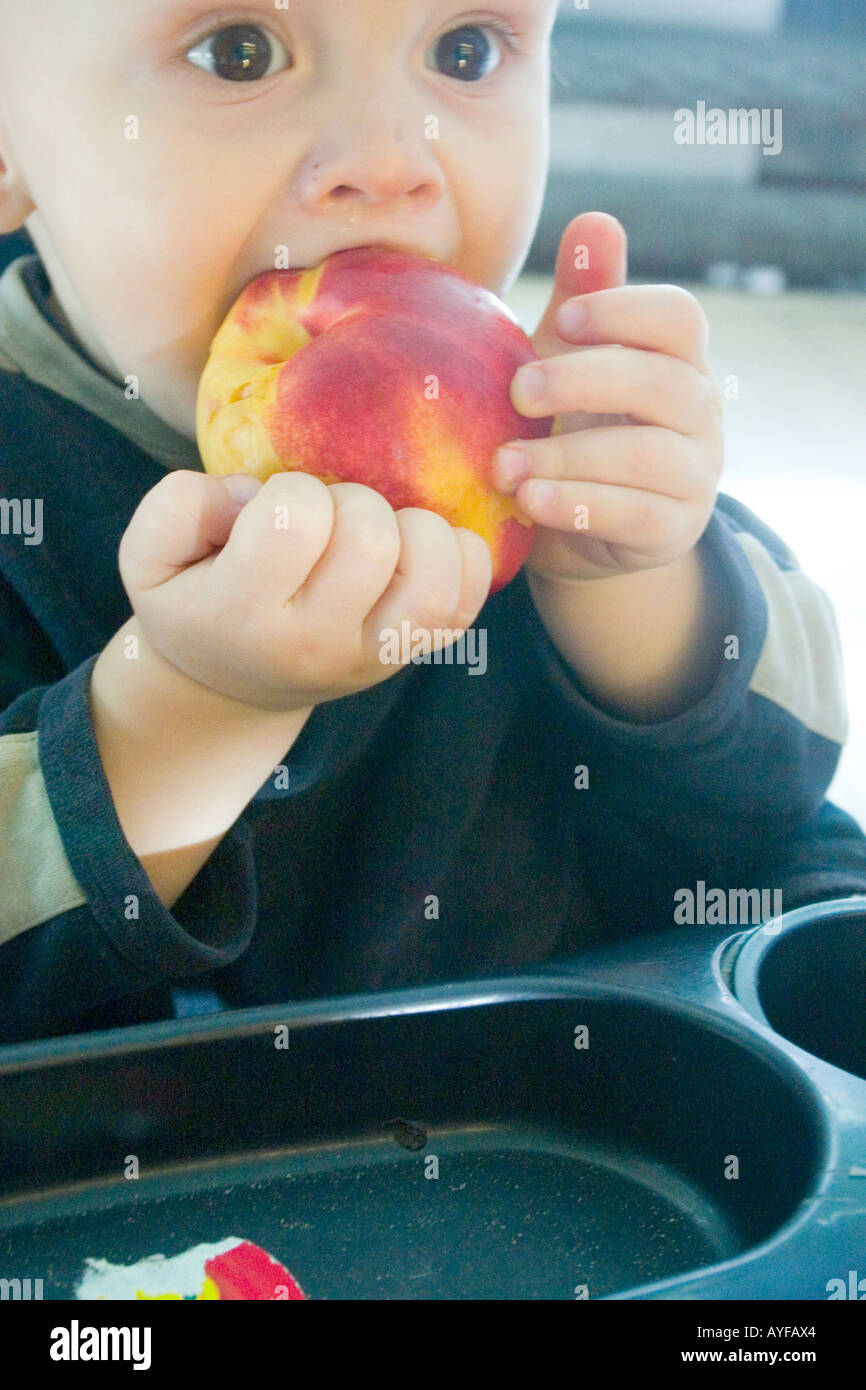 Child biting peach hi-res stock photography and images - Alamy