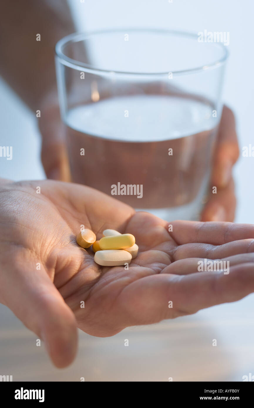 Man holding medication and glass of water Stock Photo - Alamy