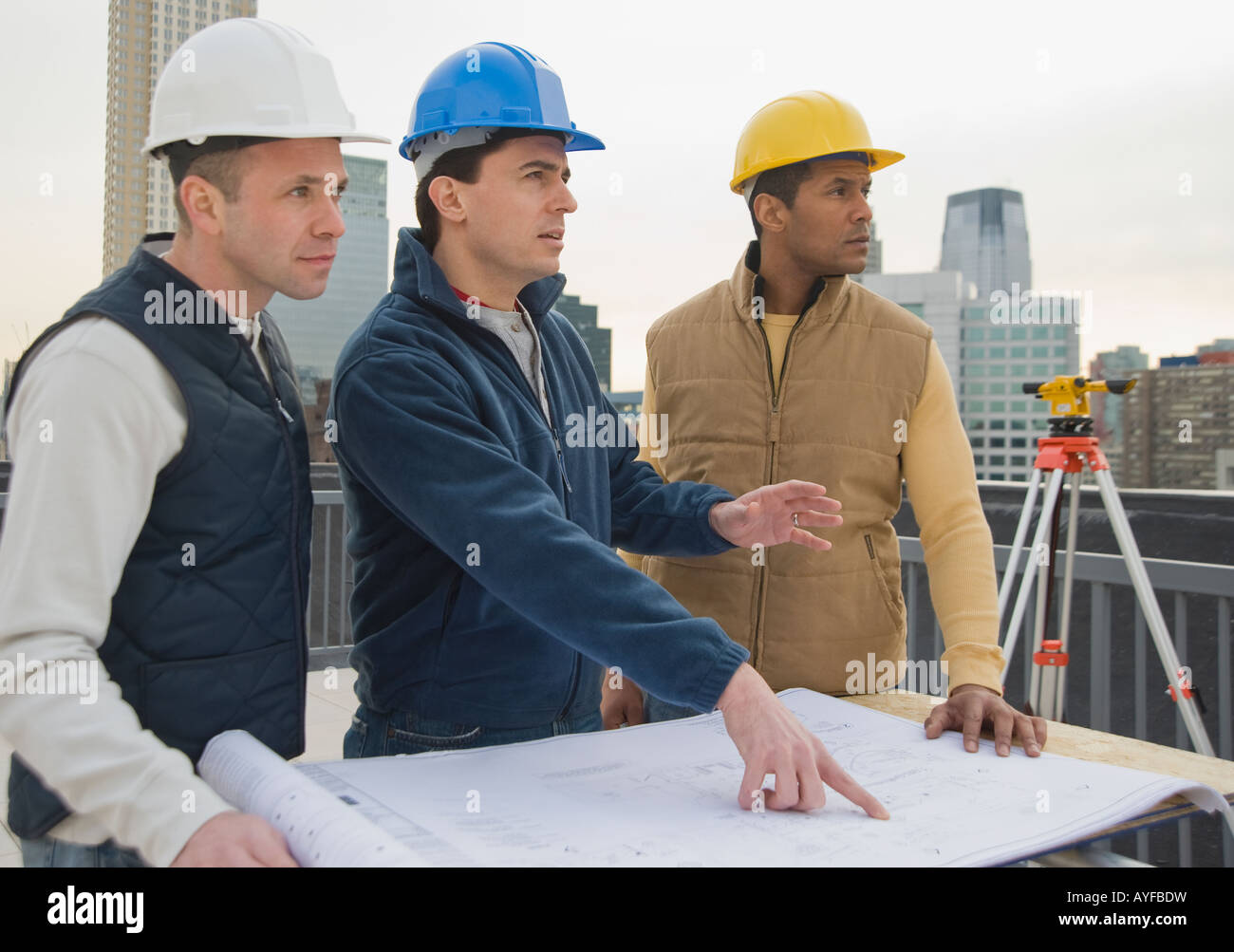 Multi-ethnic construction workers with blueprints Stock Photo - Alamy