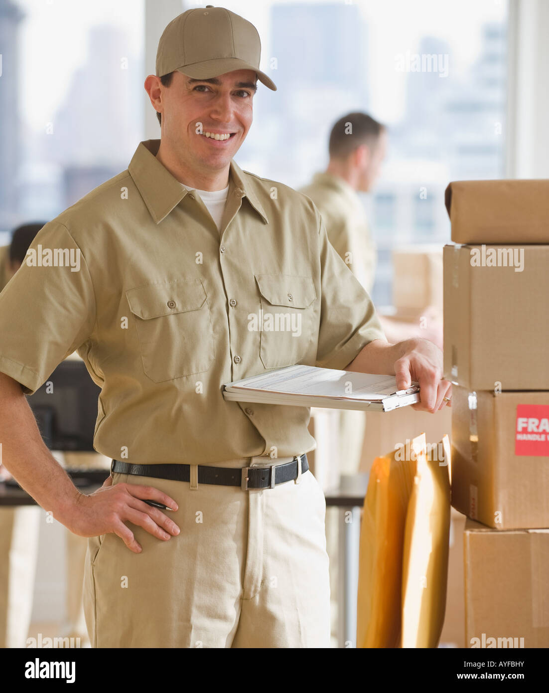 Delivery man standing next to packages Stock Photo - Alamy
