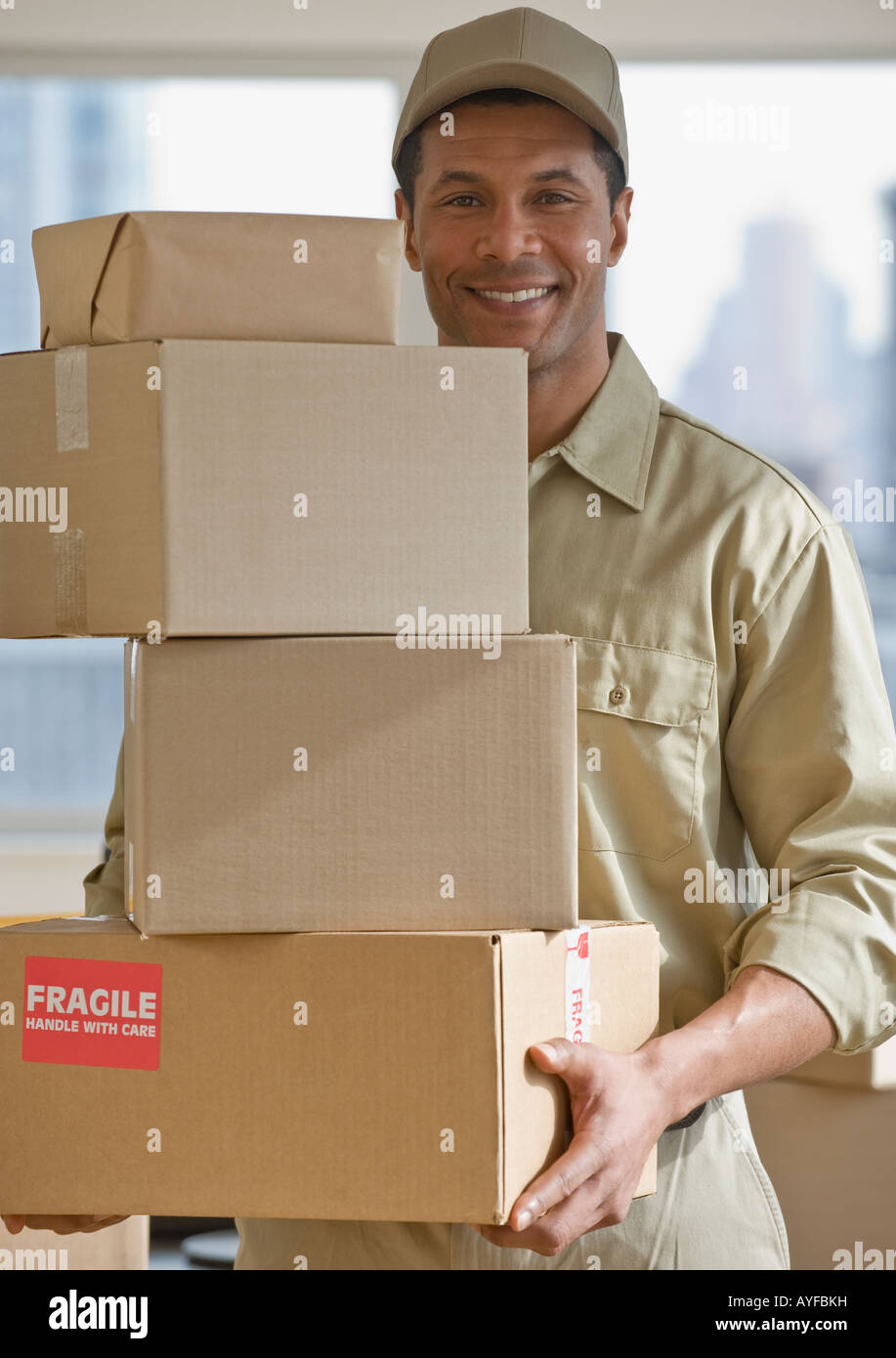 African delivery man carrying stack of packages Stock Photo - Alamy