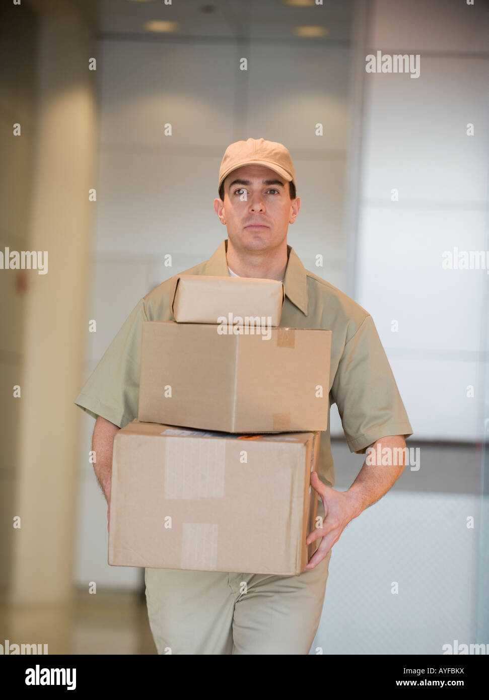 Delivery man carrying stack of packages Stock Photo - Alamy