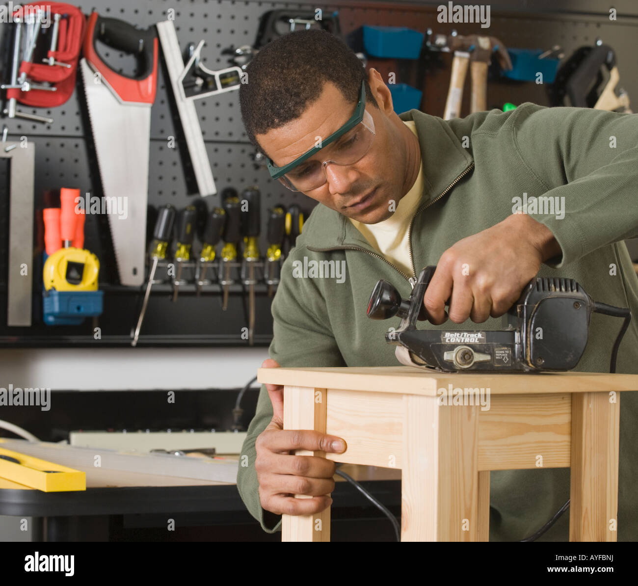 African male woodworker sanding table Stock Photo - Alamy