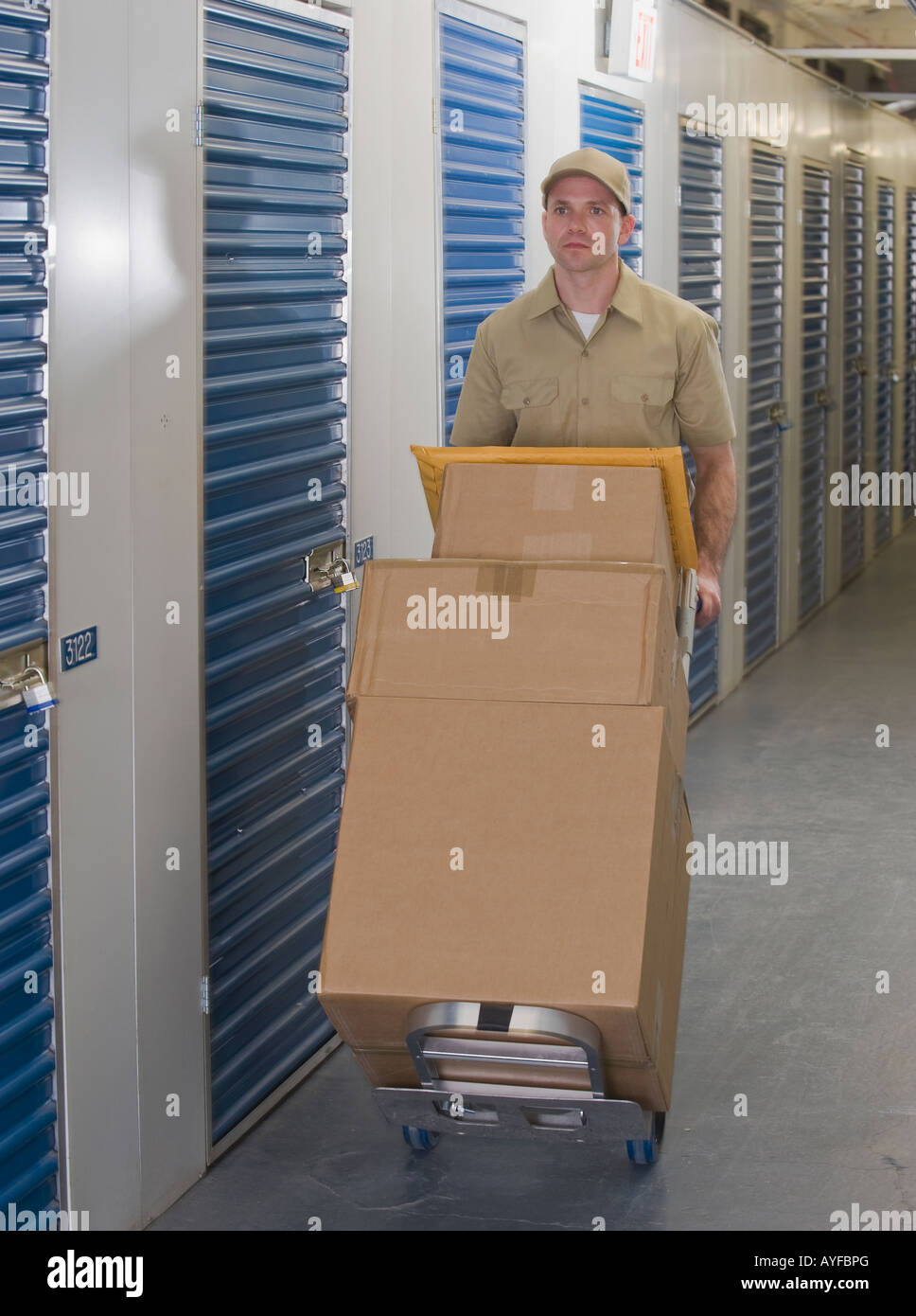 Delivery man pushing stack of packages Stock Photo - Alamy
