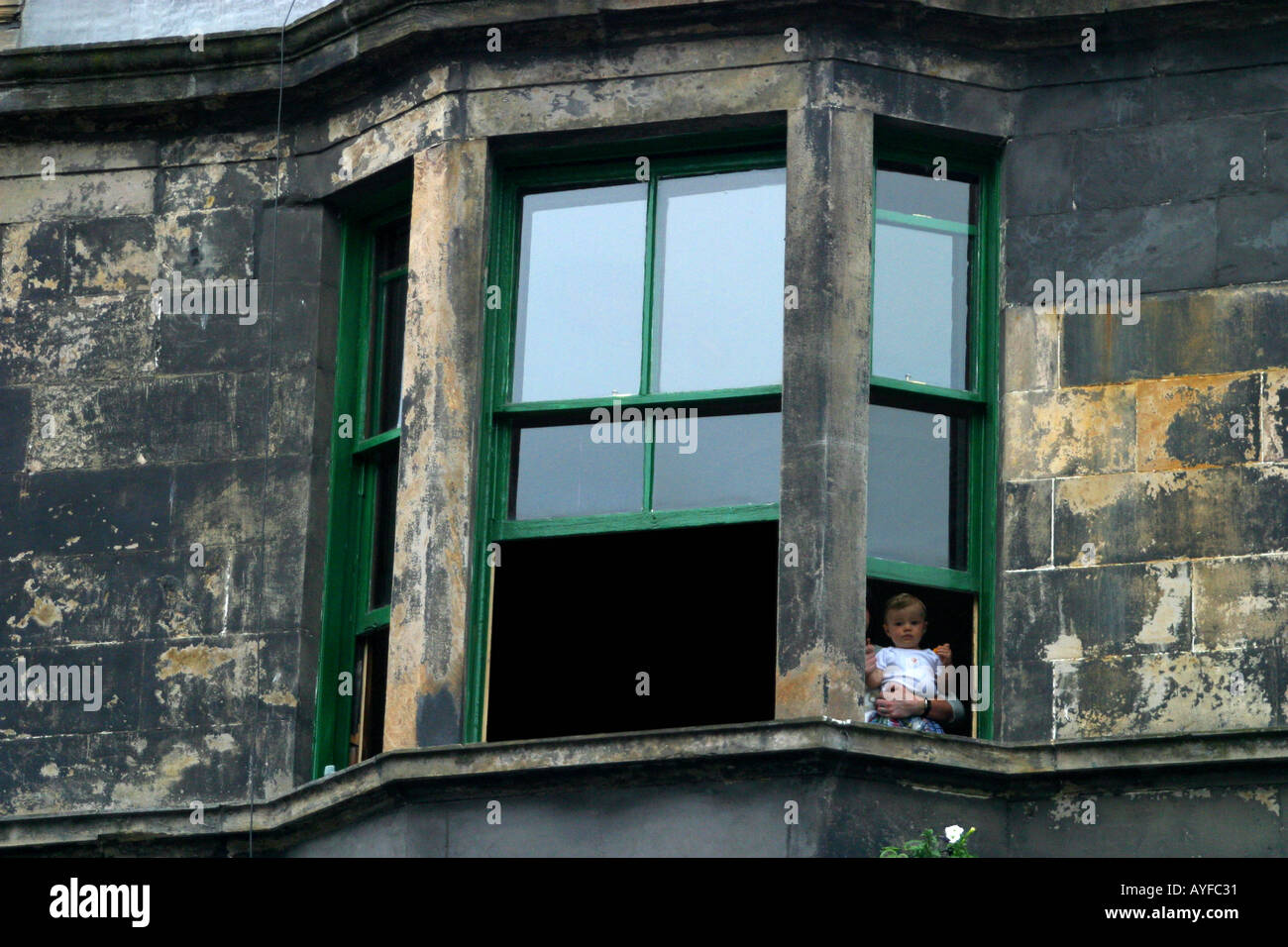 Young baby being held looking out tenement flat window Stock Photo - Alamy