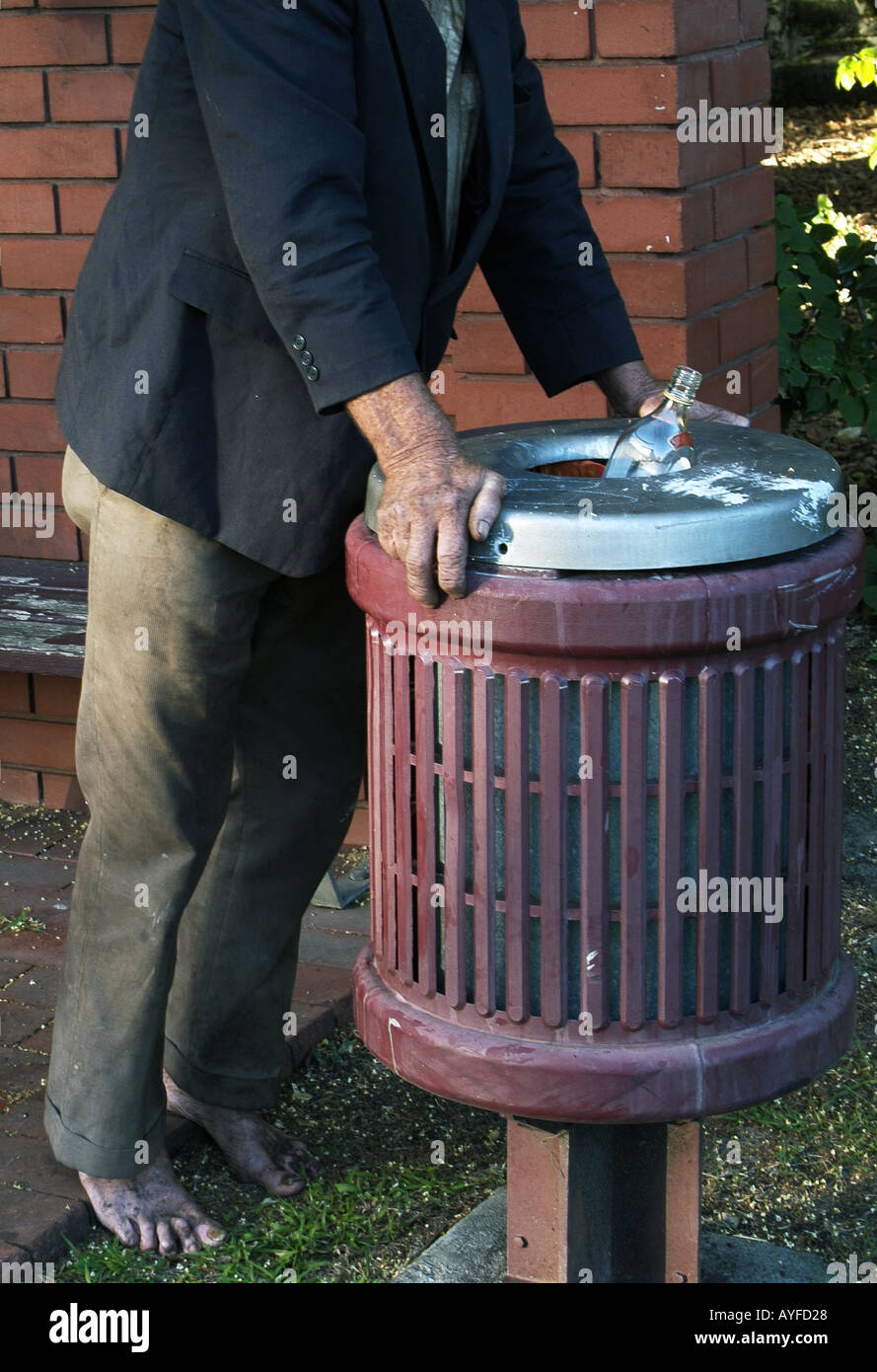 a drunk dirty homeless man leaning on a bin Stock Photo - Alamy
