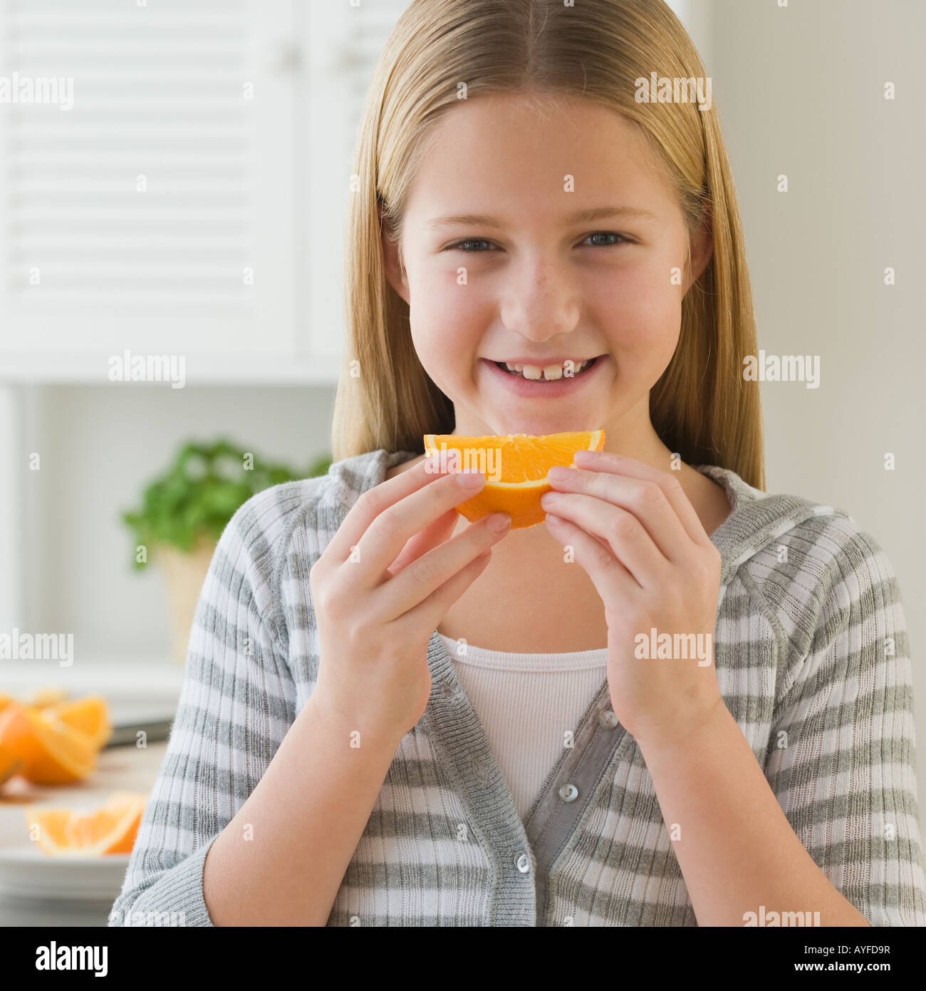 Girl eating orange slice Stock Photo - Alamy