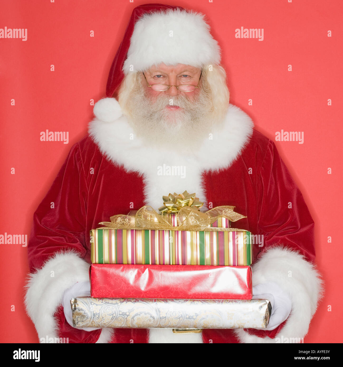 Santa Claus holding stack of gifts Stock Photo - Alamy