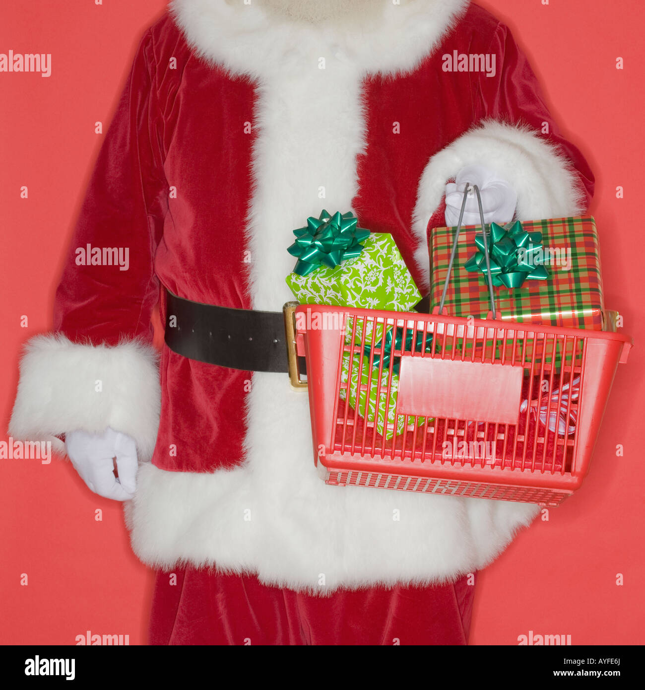 Santa Claus holding shopping basket with gifts Stock Photo - Alamy
