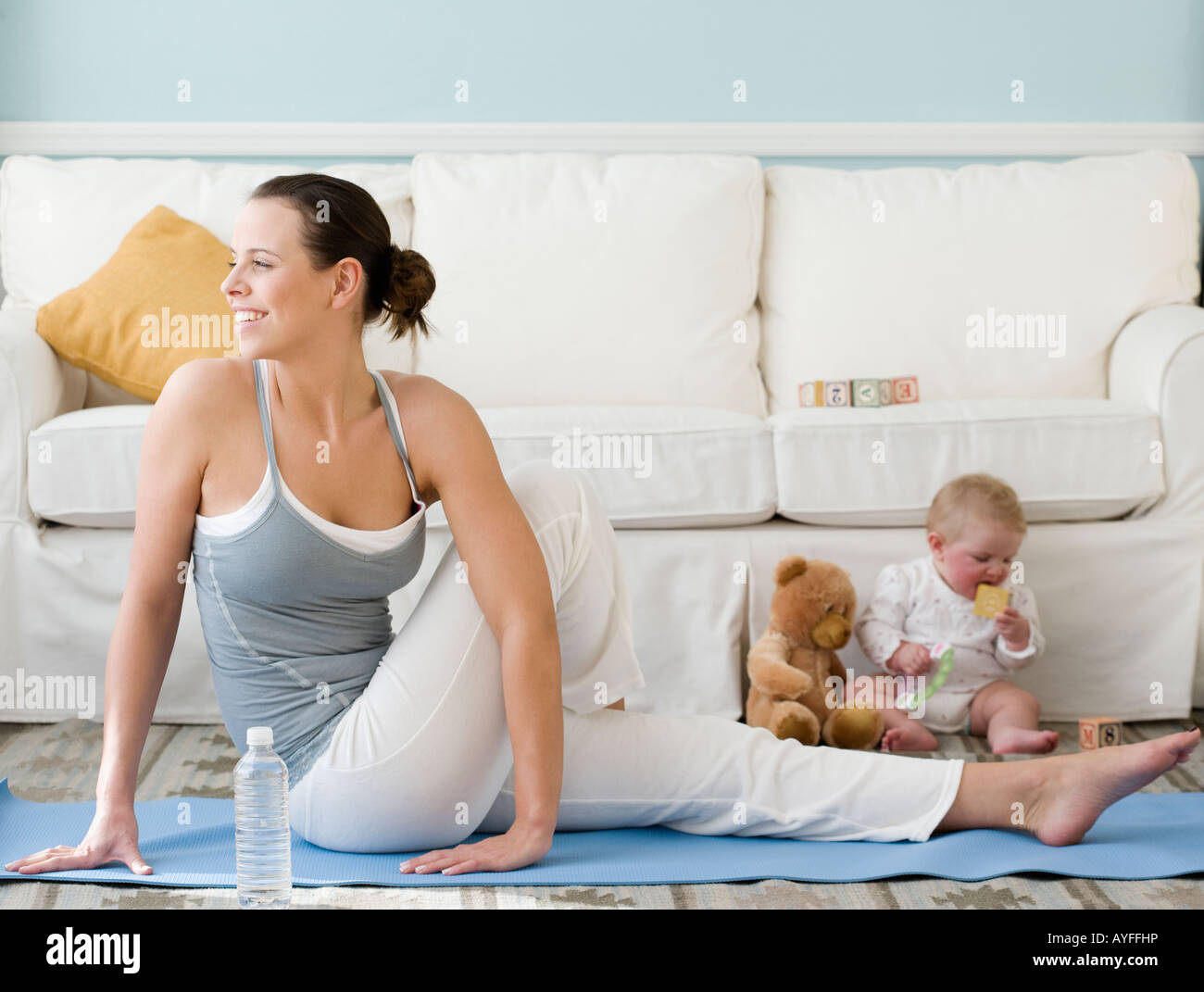 Mother practicing yoga next to baby on floor Stock Photo - Alamy