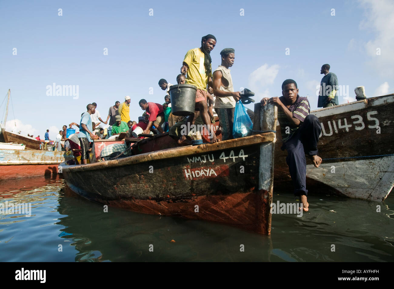 Africa Tanzania Zanzibar Stone Town Morning sun lights men aboard ...