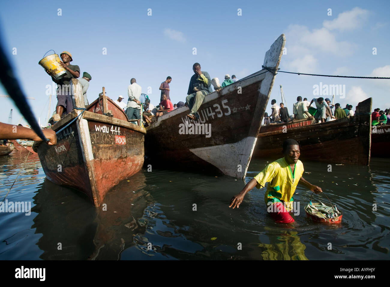 Africa Tanzania Zanzibar Stone Town Morning sun lights man carrying ...