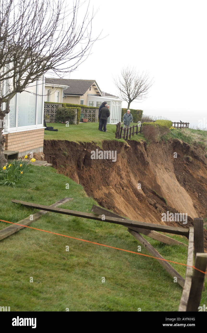 Residents looking down at cliff landslide from garden at Knipe Point ...