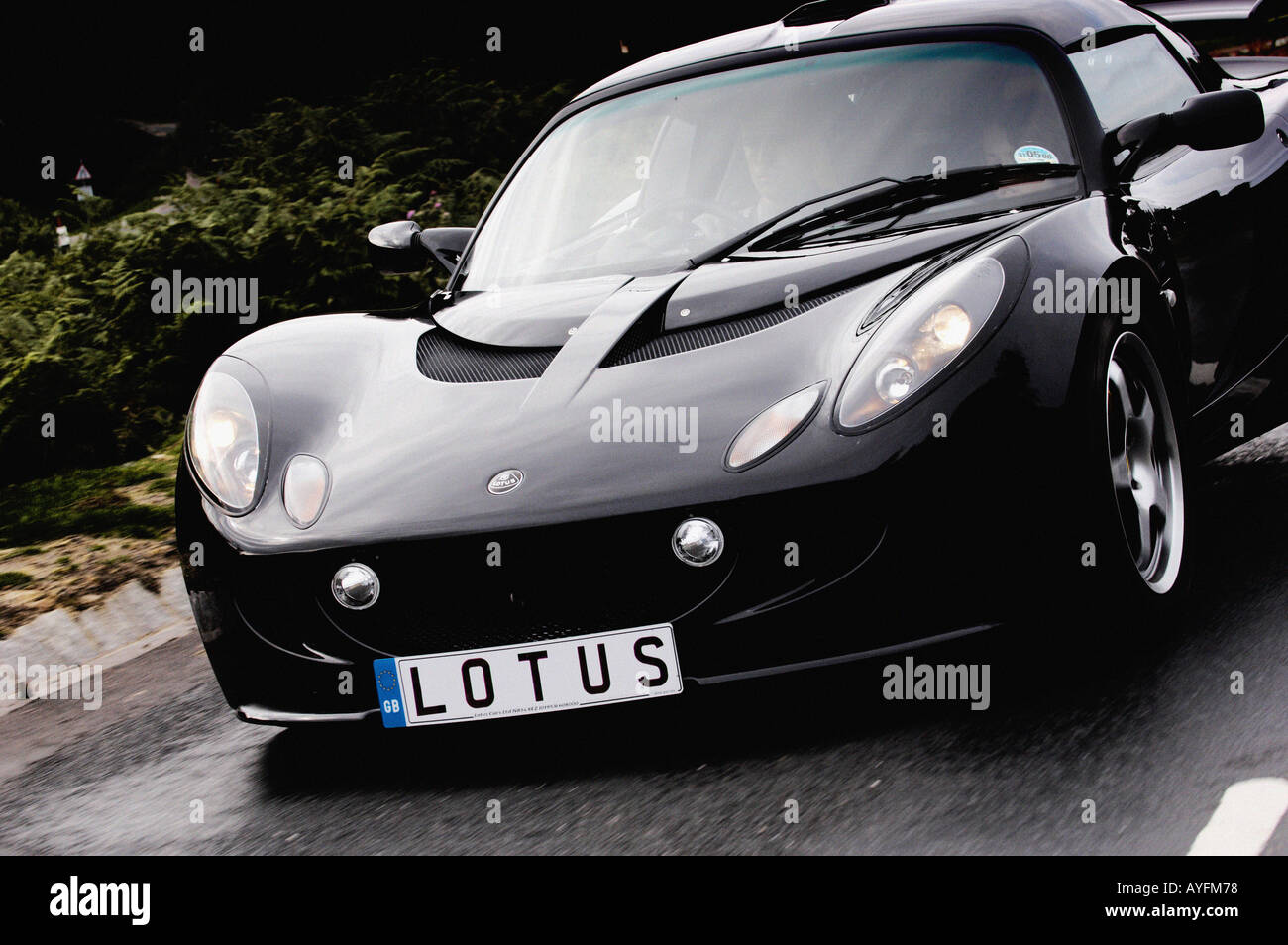 Black Lotus Exige 240r car driving on the open road with the word Lotus ...