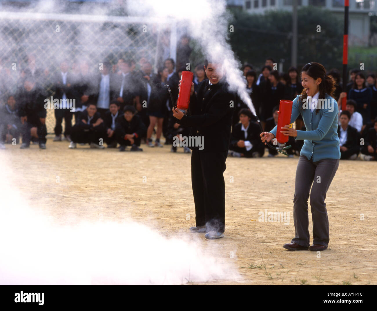 Japanese high school teacher and student practice using extinguishers ...