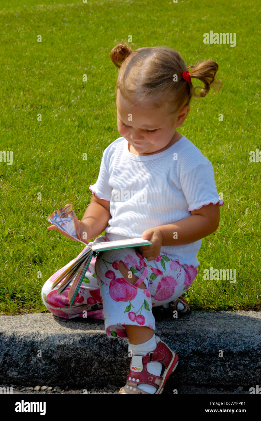 Little girl reading book Stock Photo - Alamy