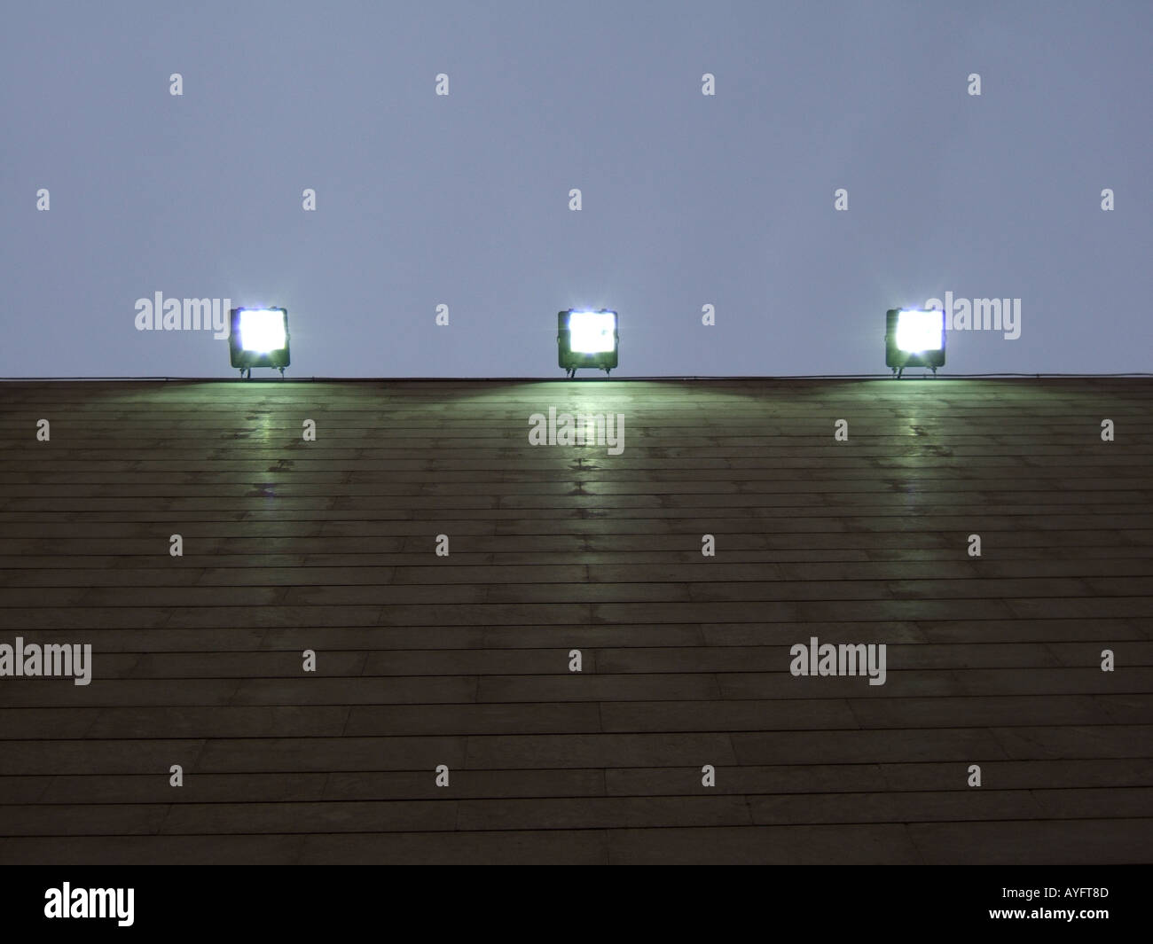 three security lights on office block Stock Photo - Alamy