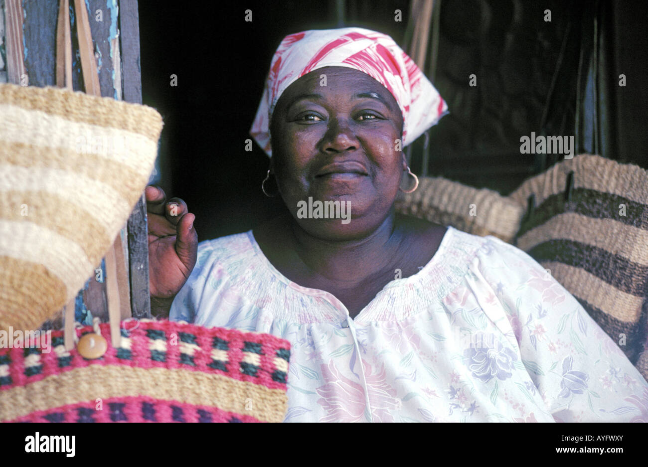 CARIBBEAN NASSAU BAHAMAS A large black woman sells straw bags and hats ...