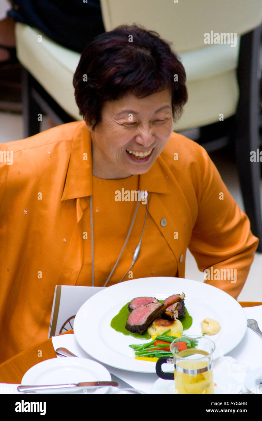Wealthy Female Asian Patron Laughing with a Big Smile sits in front of ...