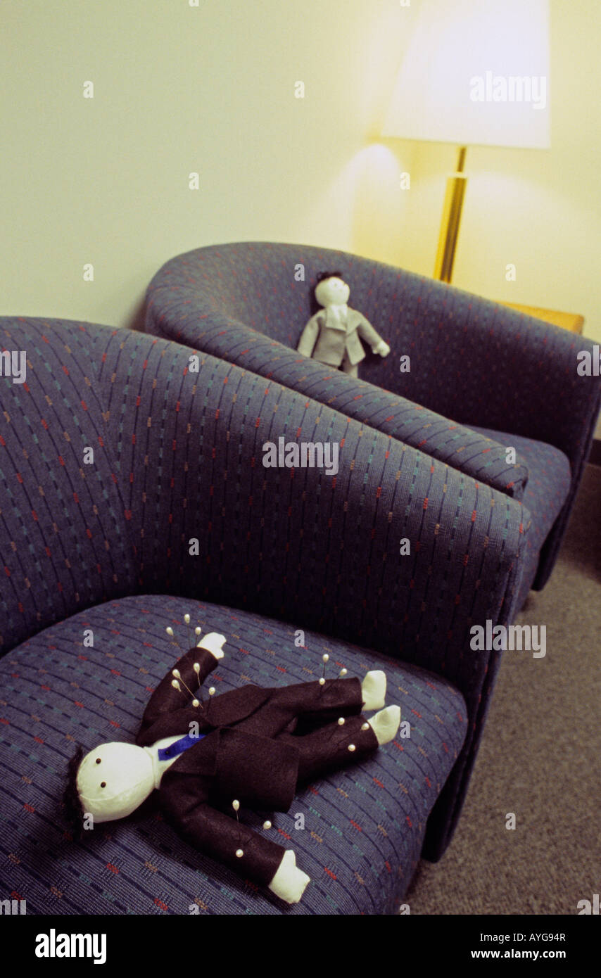 Voodoo doll lying in a chair in an office lobby in a black suit and ...