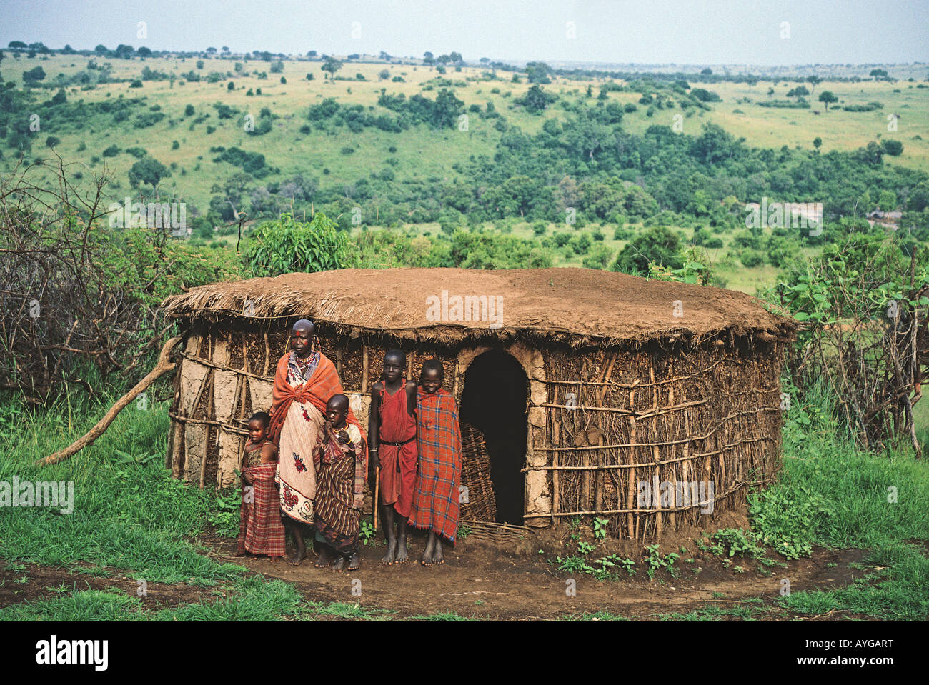 Maasai family of mother and four children outside their traditional home Masai Mara National ...